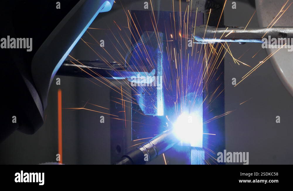 Close up of welding a joint between two steel plates. Metal in gas (MIG ...