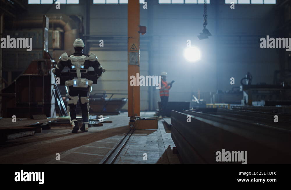 Industrial Factory Worker Wearing Exoskeleton Lifts Heavy Steel ...