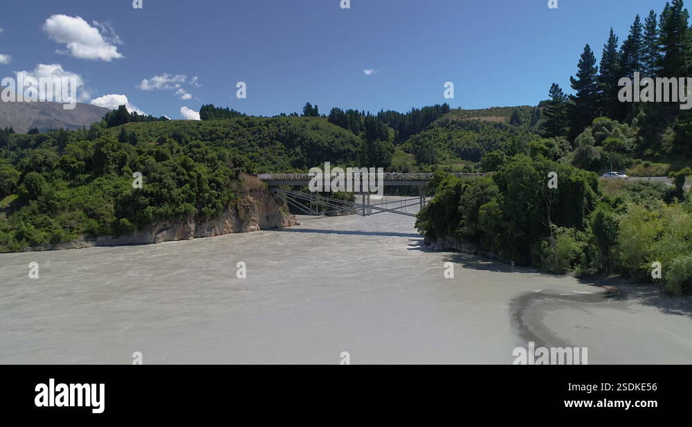 Aerial tracking and ascending view of Rakaia bridge and Rakaia river ...