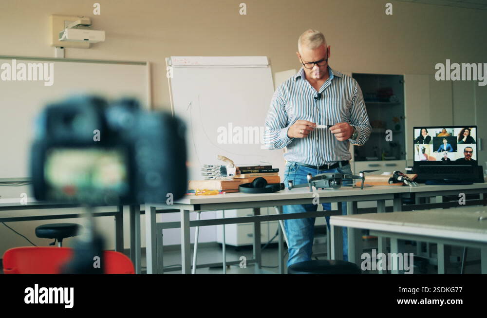 Male tutor is conducting an e-class which is being filmed live. Remote ...