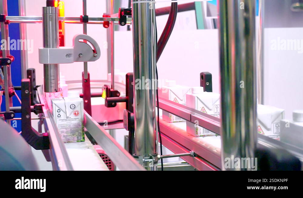 packing line. drinks packed in plastic containers move along a conveyor ...