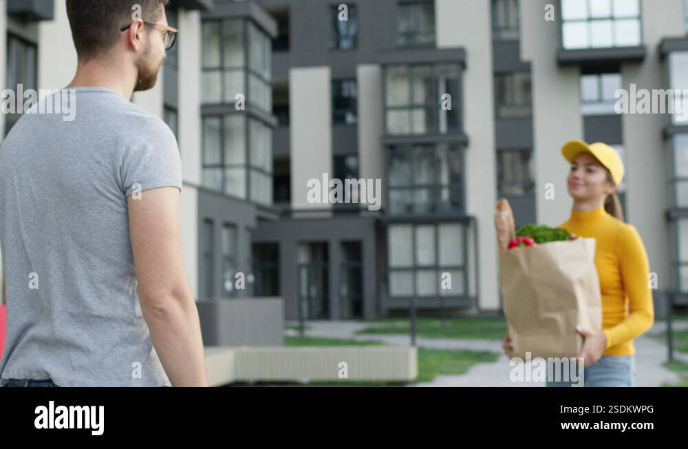 Pretty Girl Delivery Worker Hands Customer Package Of Food. Guy Takes ...