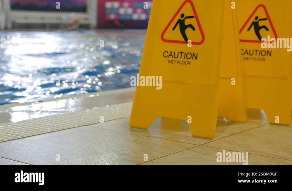 warning signs CAUTION SLIDING FLOOR installed near the pool with water ...