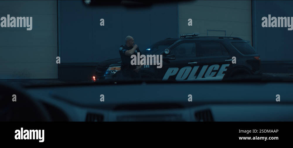 Caucasian male police officer standing guard in the street near police ...
