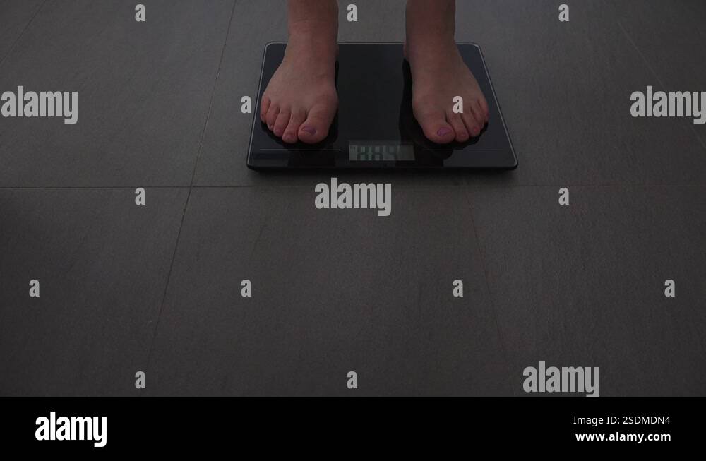 woman measuring herself on weight scale a scale Stock Video Footage - Alamy