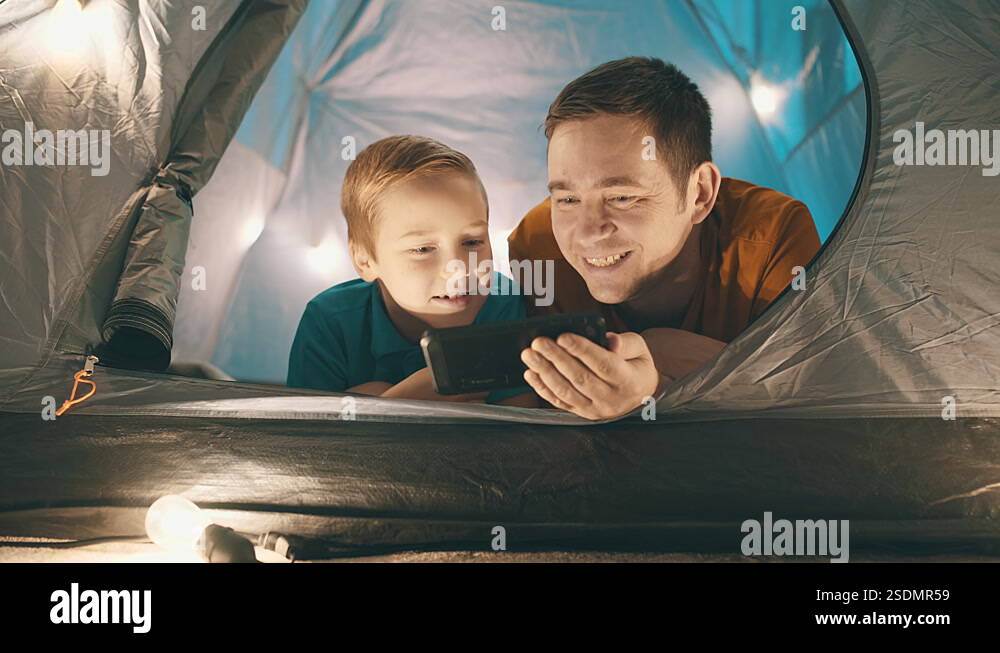 Father and son watching smartphone, talking on video call. Family ...