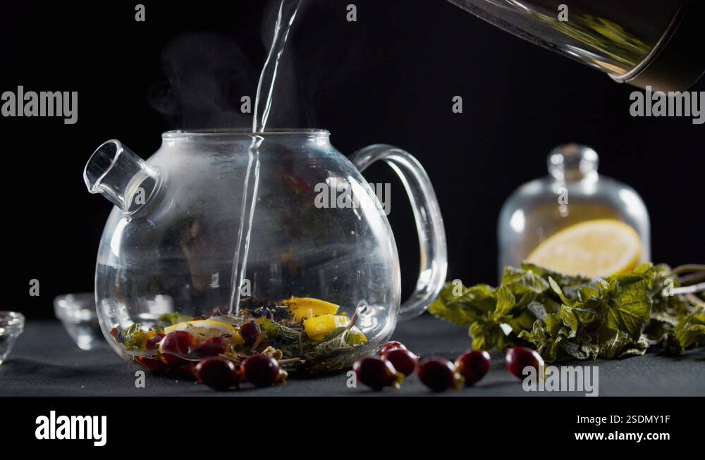 Pouring boiling water into a teapot with herbs, fruits and tea, hot beverage, 4k Stock Video ...