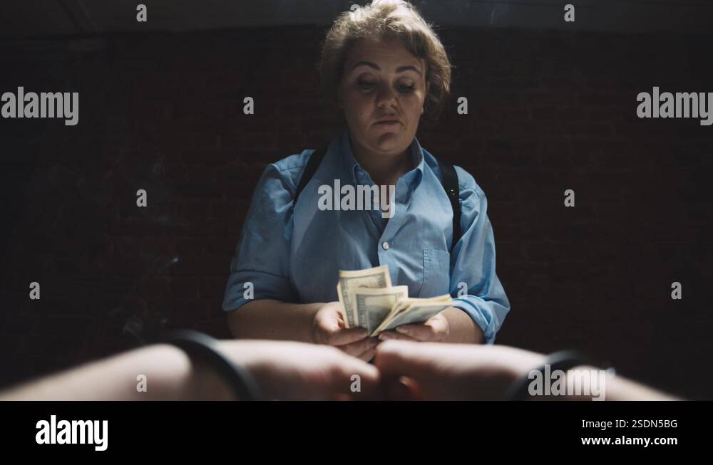 Close up of suspect hands in handcuffs giving money to female police ...