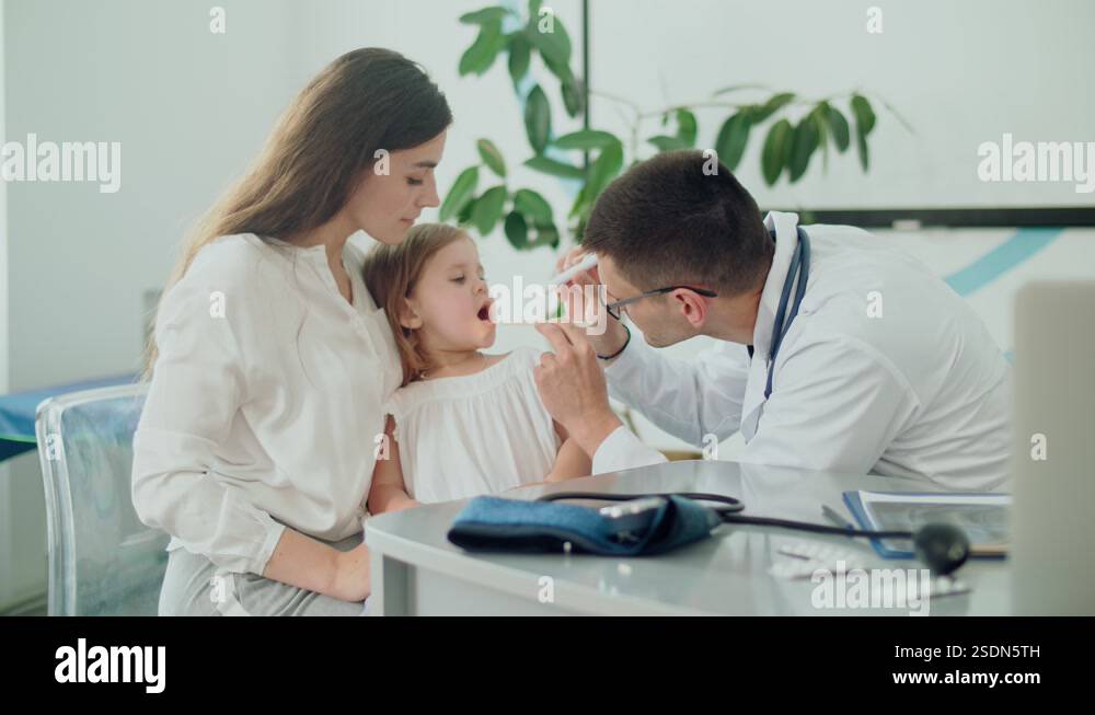 Male Doctor Pediatrician Examining an Ill Sad Kid at Medical Visit With ...