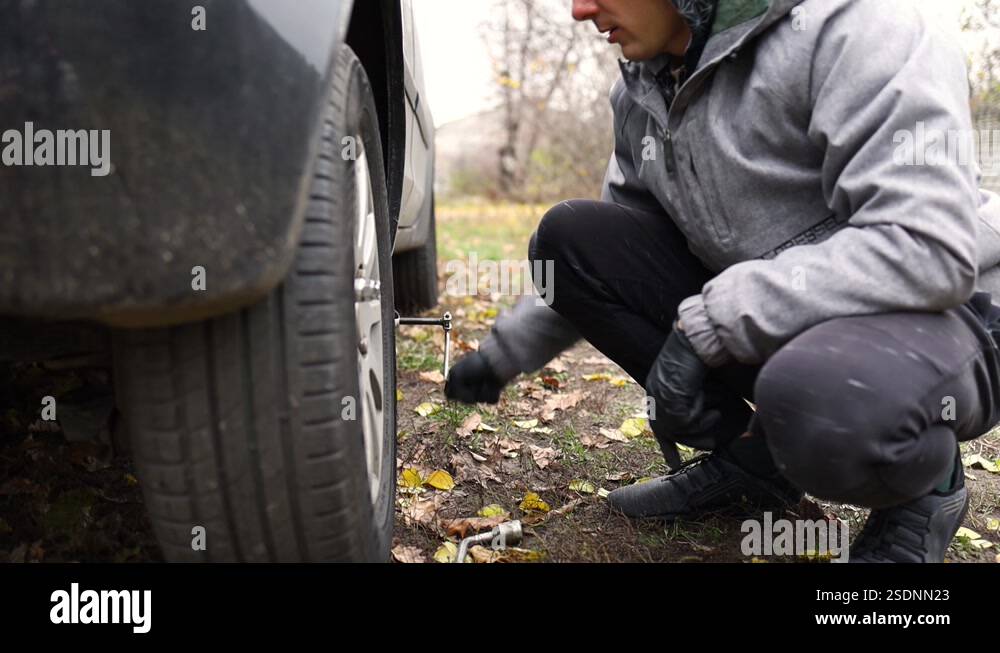 Wheels Installing For Winter Season At Autumn. Man Is Changing Wheel Of ...