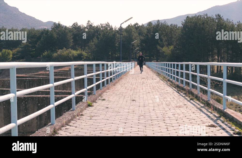 Man running on a dam slow motion. Fit male athlete sprinting. Exercise ...