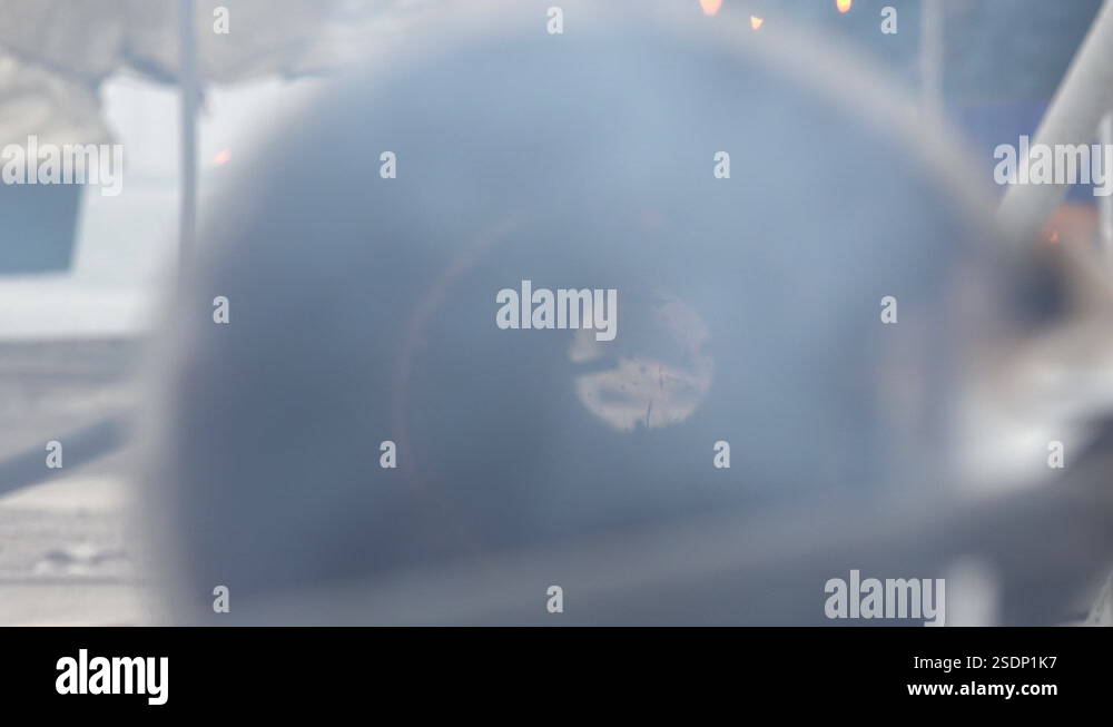 Steam, smoke, fire and sparks from pipe welding. View through pipe to ...