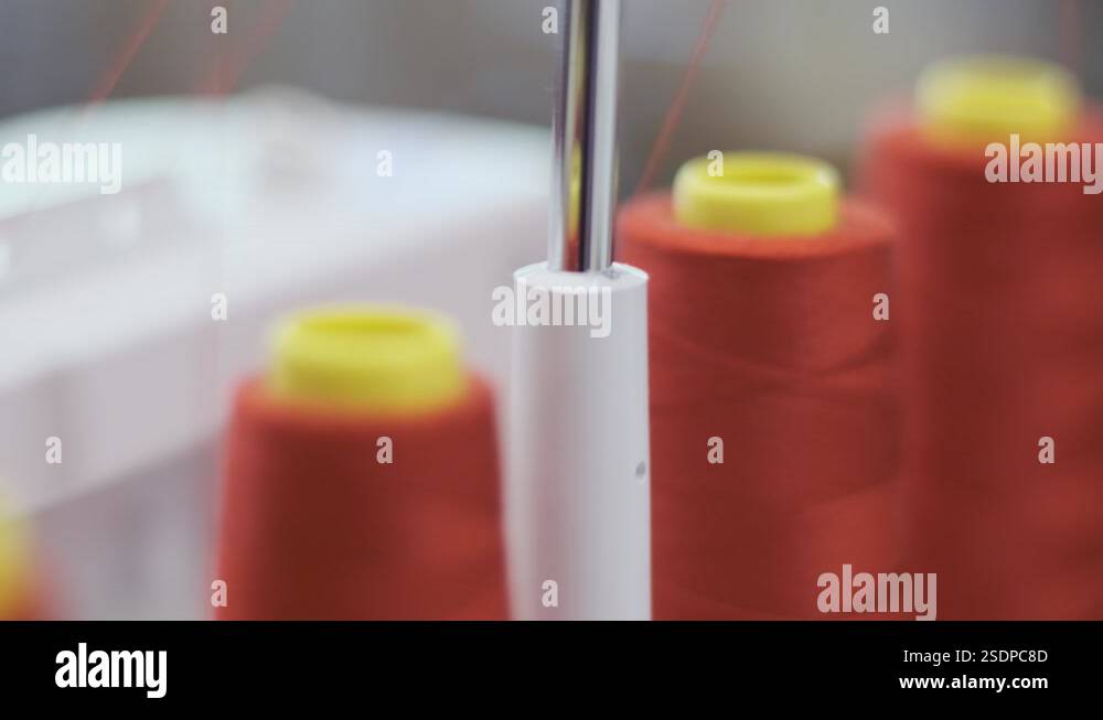 Red yarn spools of an overlock sewing machine. Slow Motion. High ...