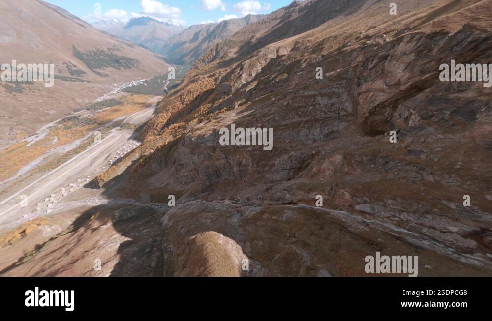 Speed flight dive close past mountain rocky slopes to deep canyon with ...