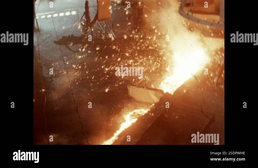 1950s: Interior steel mill. Smelting room with molten metal. Sparks and ...