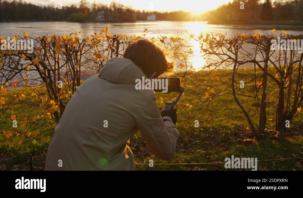 Vlogger boy with mobile phone camera stabilizer recording video blog in ...