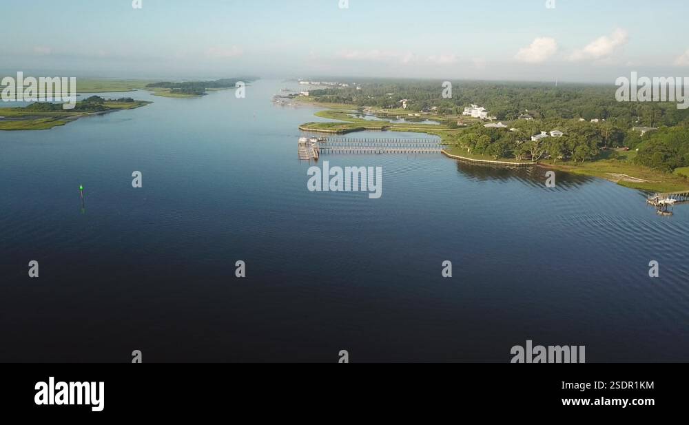 Peaceful sunrise pan left flyover of piers, houses, and marsh at Trails ...