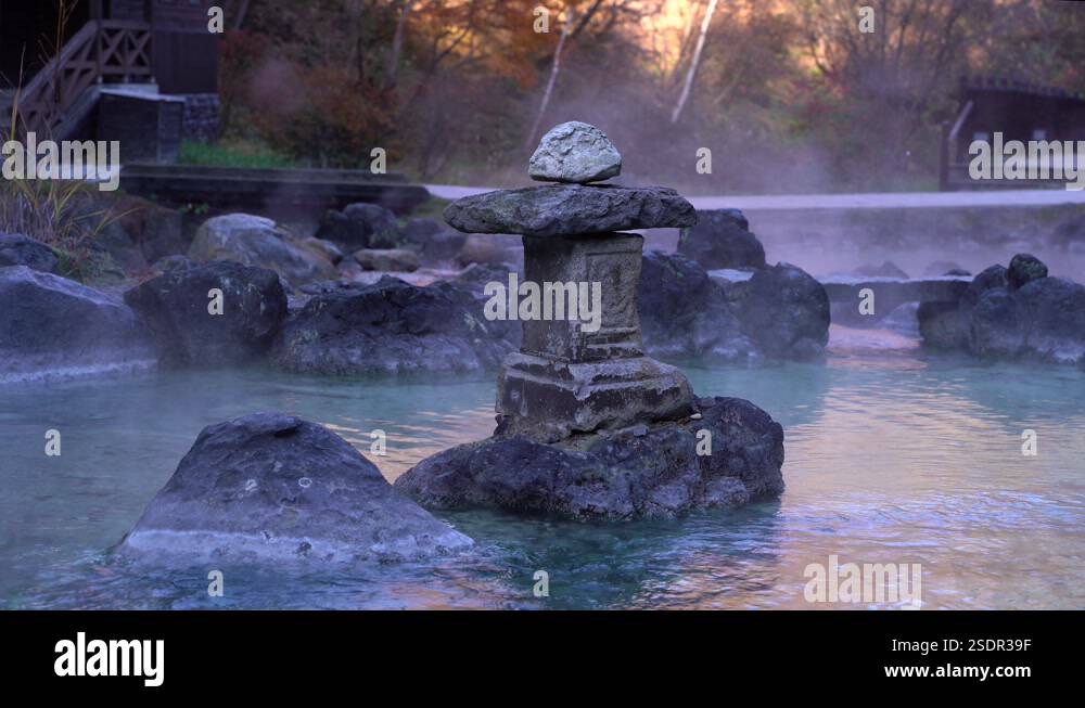 Tight shot of stone pillar inside steaming onsen hot springs in Japan ...
