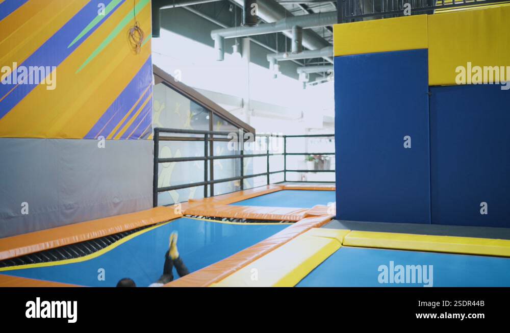 Athlete jumping on trampoline in an indoor bounce hall. Young fit man ...