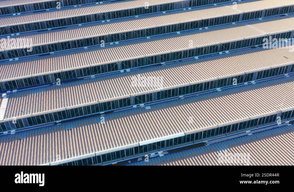 Saw-tooth metal roof of a big factory in a production plant - abstract ...