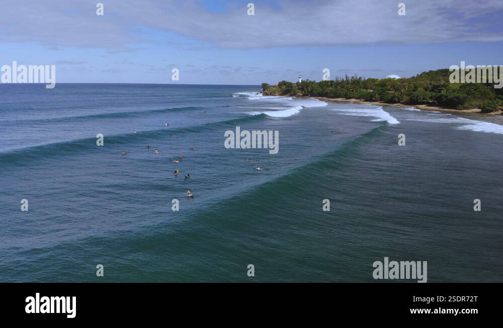 Drone holding still while filming surfers floating in the ocean near ...