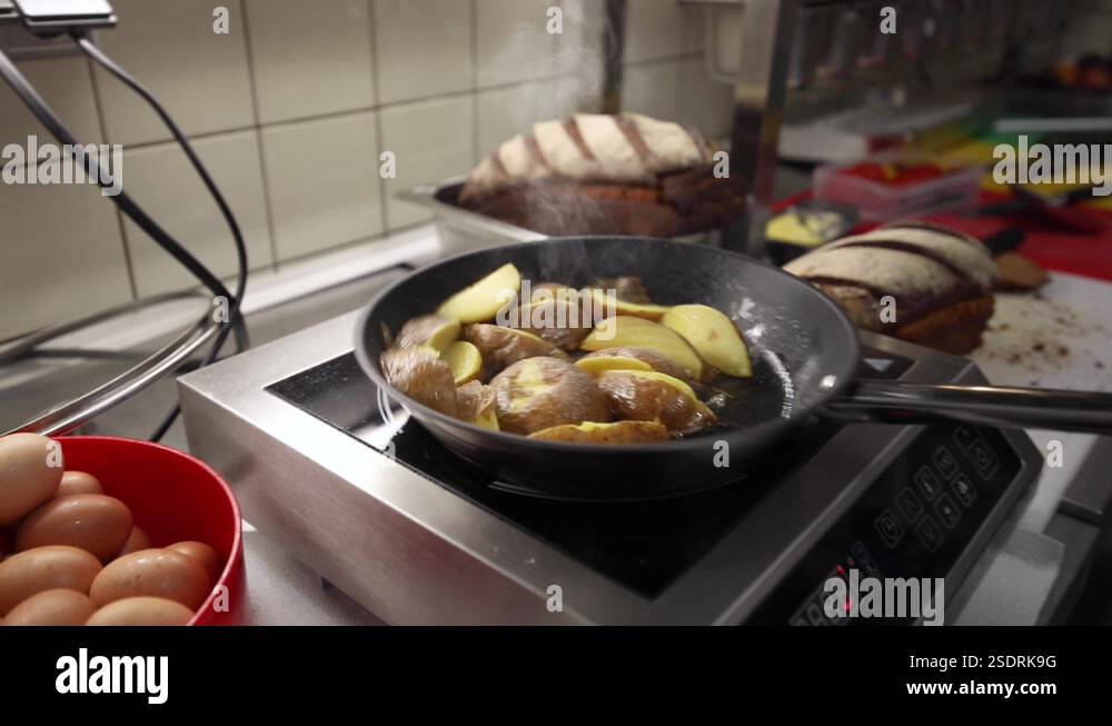 Frying And Pan-flipping Potatoes Over Induction Cooker In The Kitchen ...