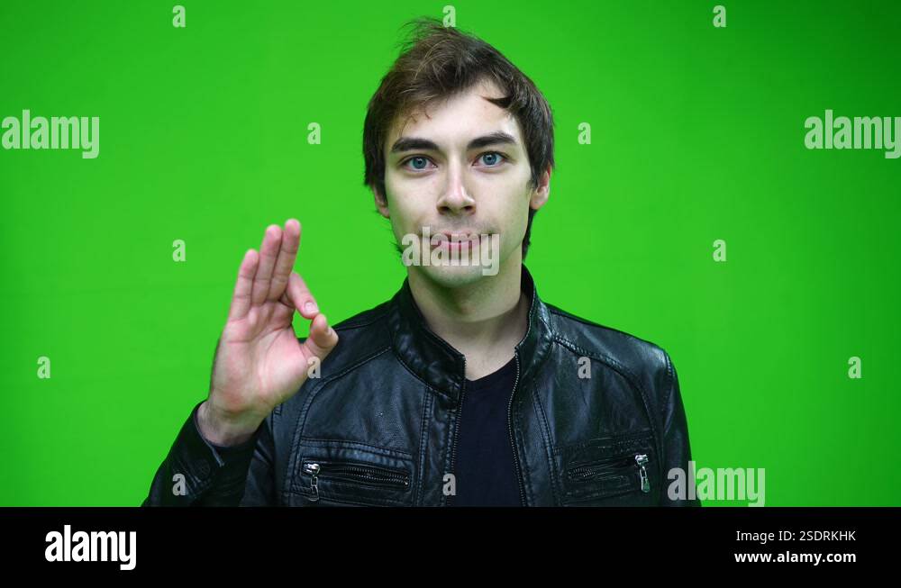 White man in leather jacket showing approval or ok sign on green screen ...