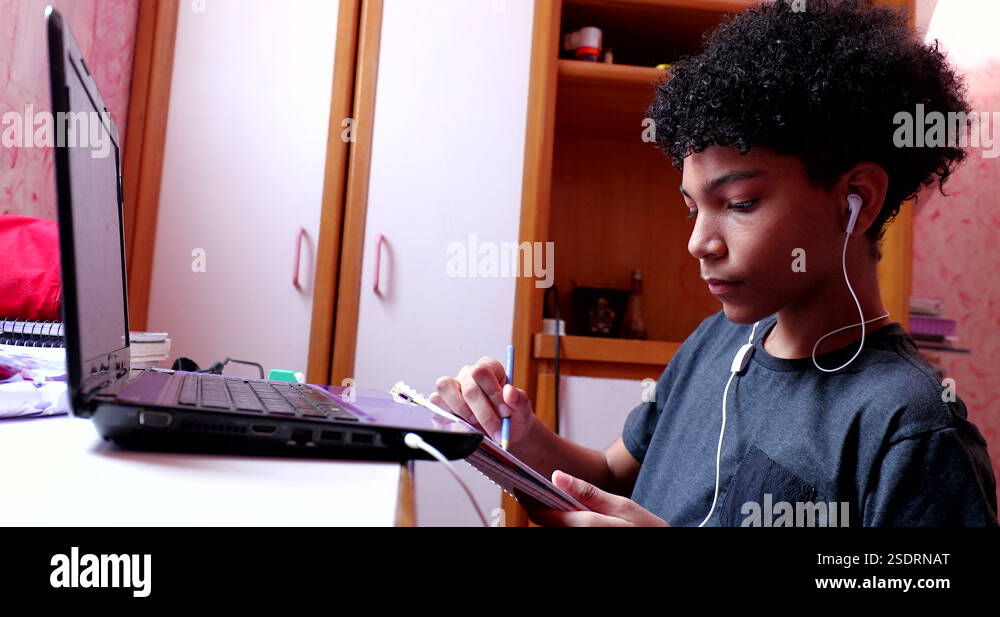 Mixed race kids doing homework at home writing on notepad and looking ...