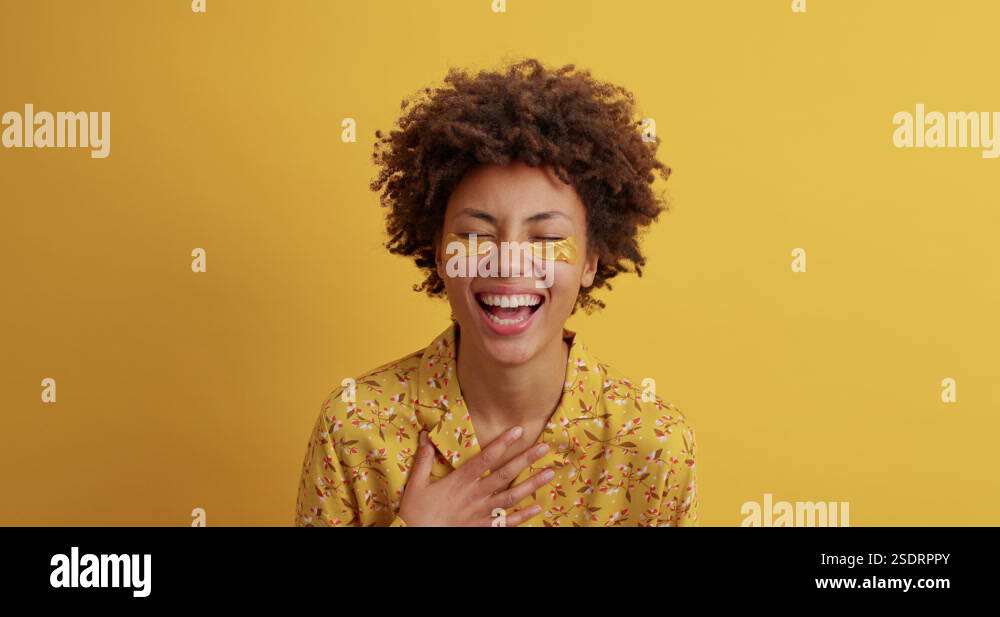 Beautiful young woman laughs happily expresses positive emotions wears ...