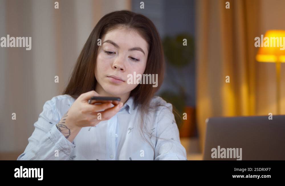 Young asian woman sitting at home and scanning qr code on receipt with ...