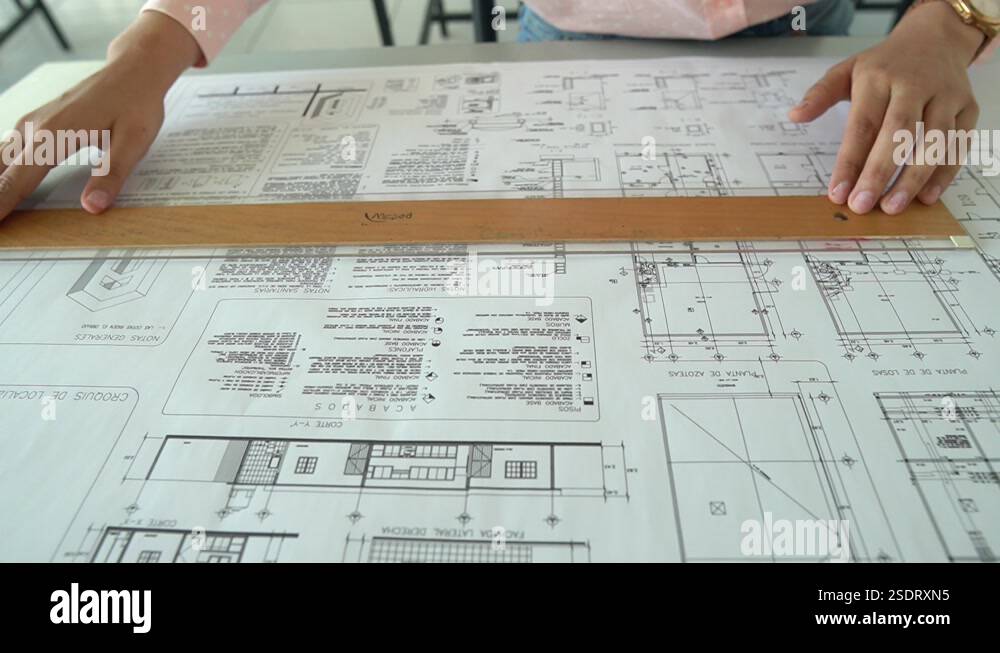 architect making old-fashioned drawings on his plans with paper and T ...
