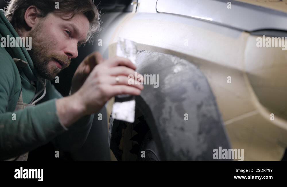 The man works in a tuning studio. Car tuning. The building of the car's ...