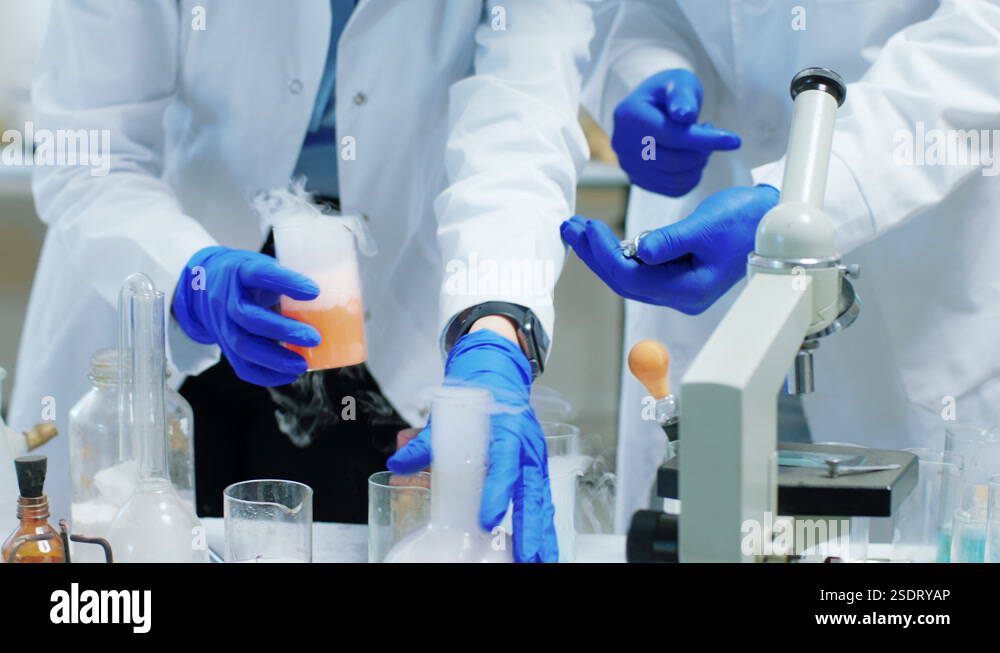 Details closeup of a chemical experiment two students in the ...
