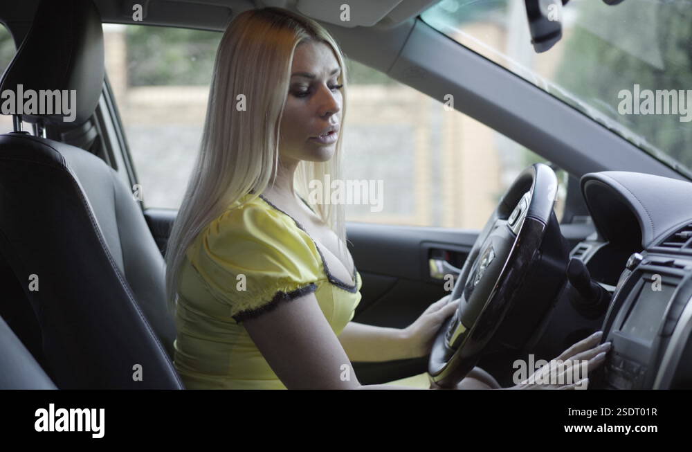 Side view of scared young blondie pushing button in car and leaning ...