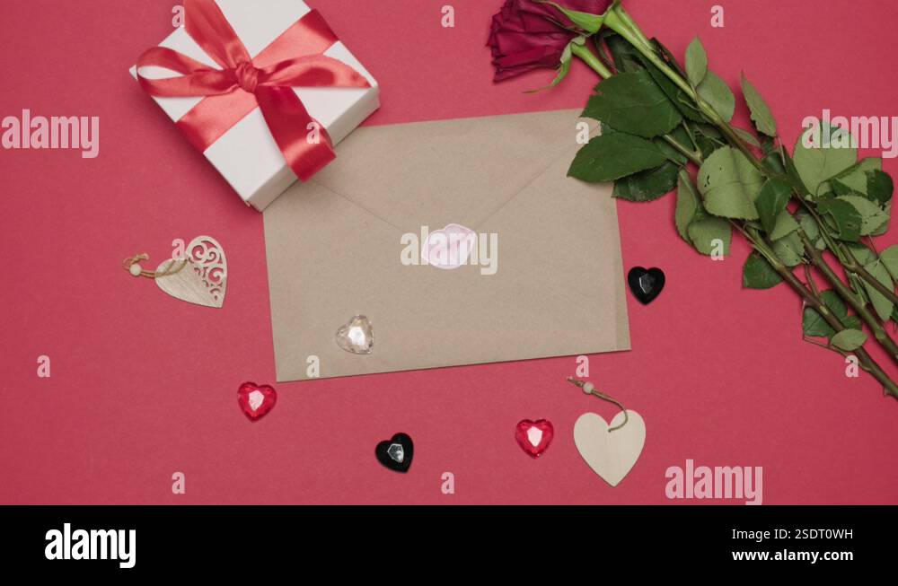 Craft letter with a kiss sticker on a pink background. A bouquet of red ...