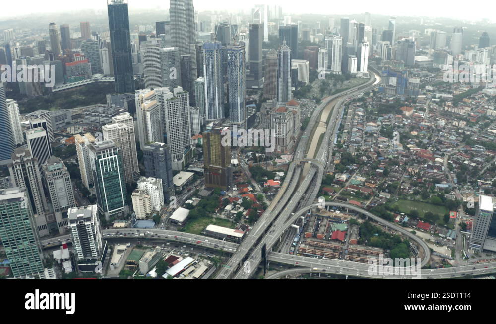 Aerial view of Kuala Lumpur highway and city skyline, tilt up reveal ...