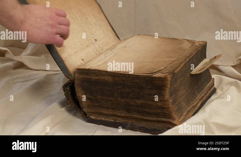 Close slomo slide shot of male hand opening worn old heavy bible Stock ...