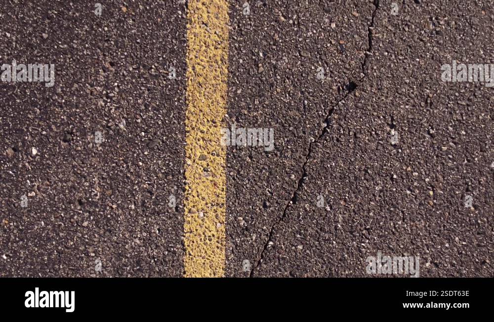 Yellow Line Marking Across Cracked Asphalt Pavement - Closeup, Vertical ...