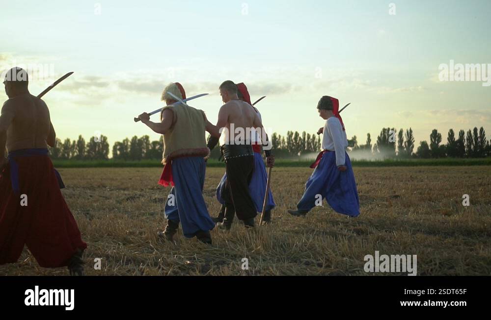 Group of Cossack men in traditional clothes swinging and spinning sharp ...