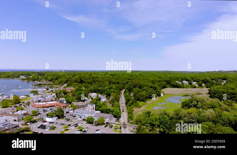 Angled birds eye view of train running on track through dense greenery ...