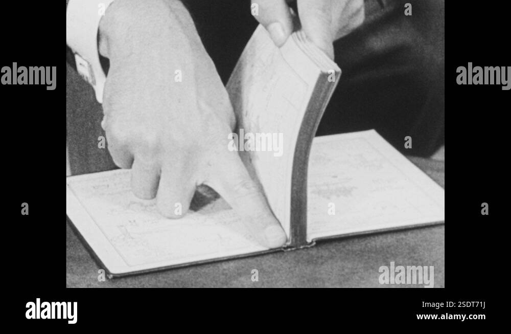 1950s: Man opens small book, presses fingers along binding Stock Video ...