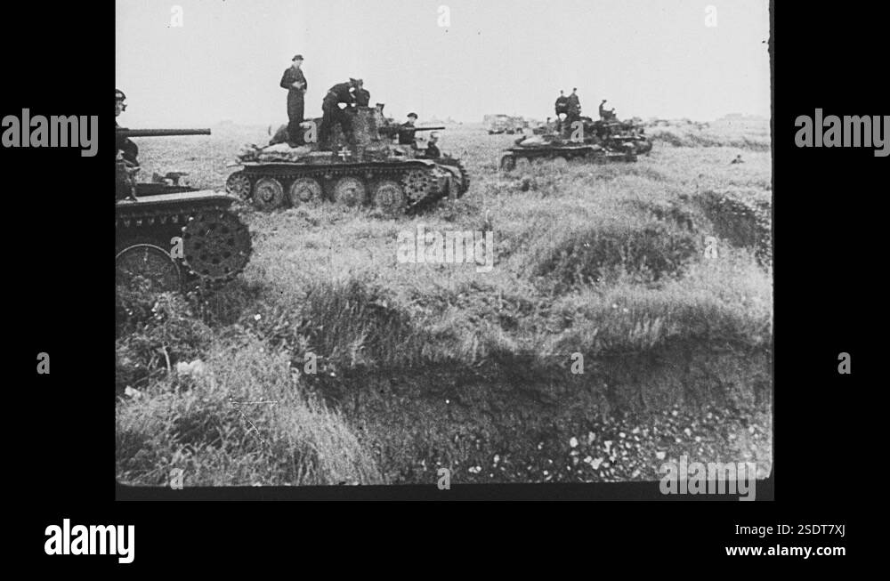 1940s: Soldiers along beach in water. Tanks on hill overlooking beach ...