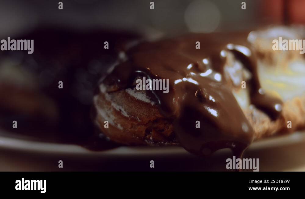French dessert- chocolate eclair. Pouring melted chocolate on eclairs ...