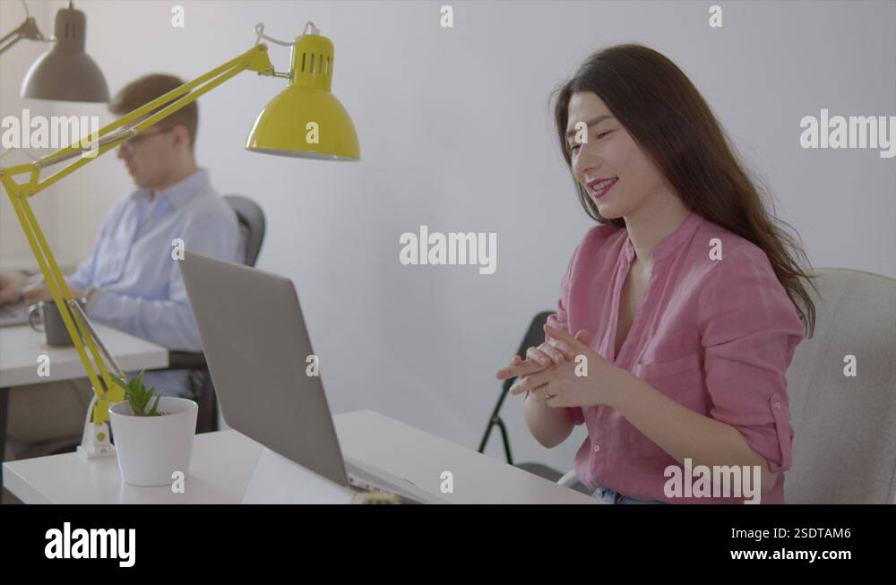 Asian woman operator with headset sittig in front of laptop friendly ...