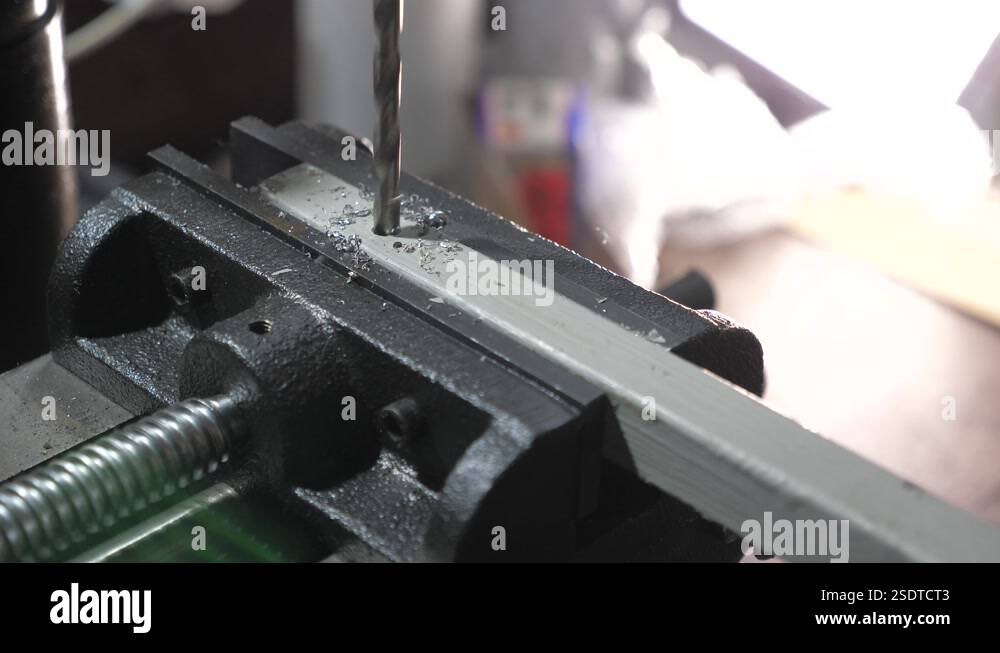 The drilling machine drills a hole with a bore in a metal part. A ...