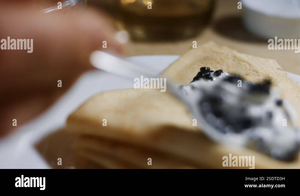 Spreading lump fish black roe with taramasalata on blinis. Isolated ...
