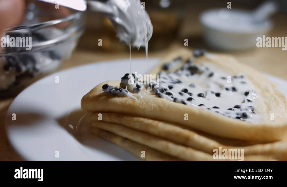 Spreading lump fish black roe with taramasalata on blinis. Isolated ...