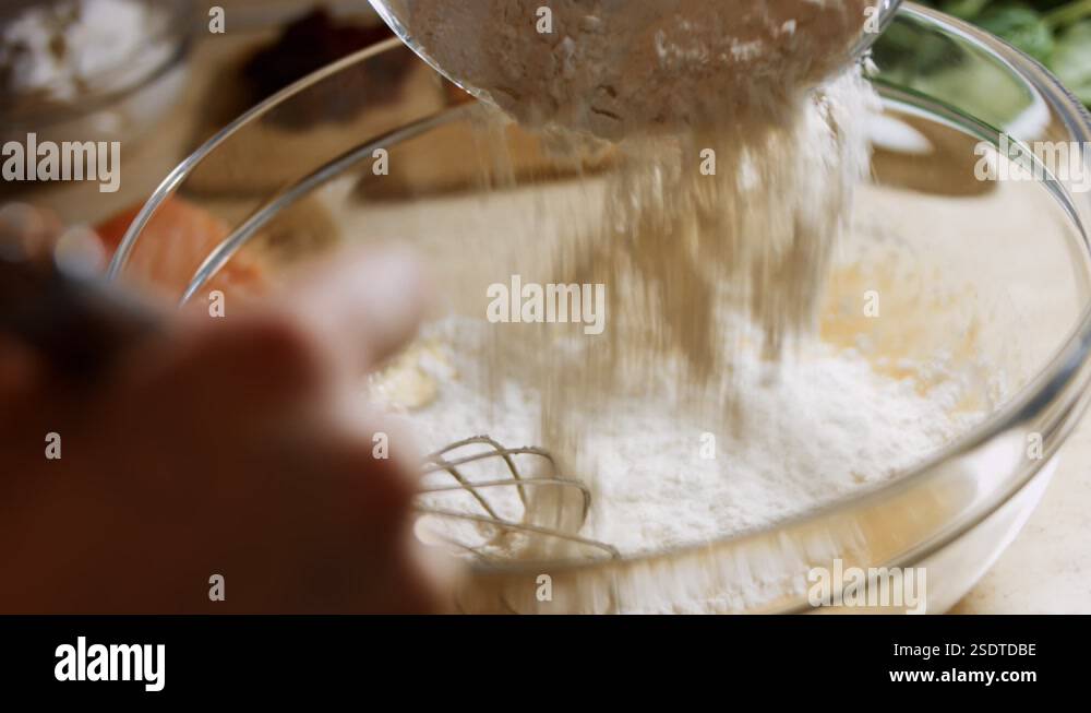 Mixing fresh eggs and flour with steel hand mixer in a glass bowl. Process of Stock Video ...