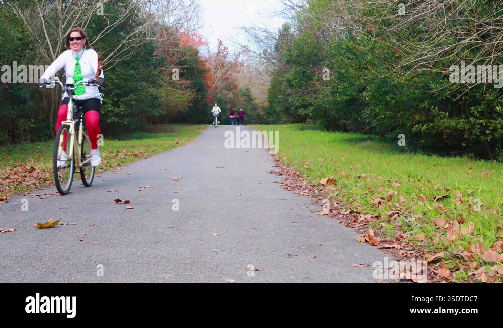 Augusta Canal A lady in a holiday outfit rides a bicycle by on a trail ...