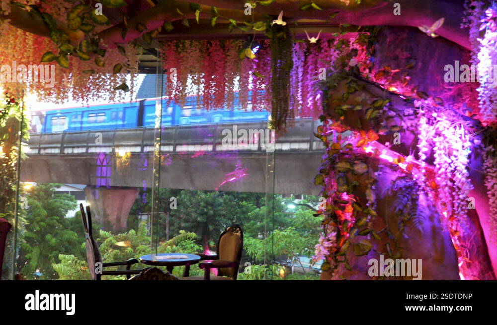 BTS Train passes outside window of colorful forest themed cafe, panning ...